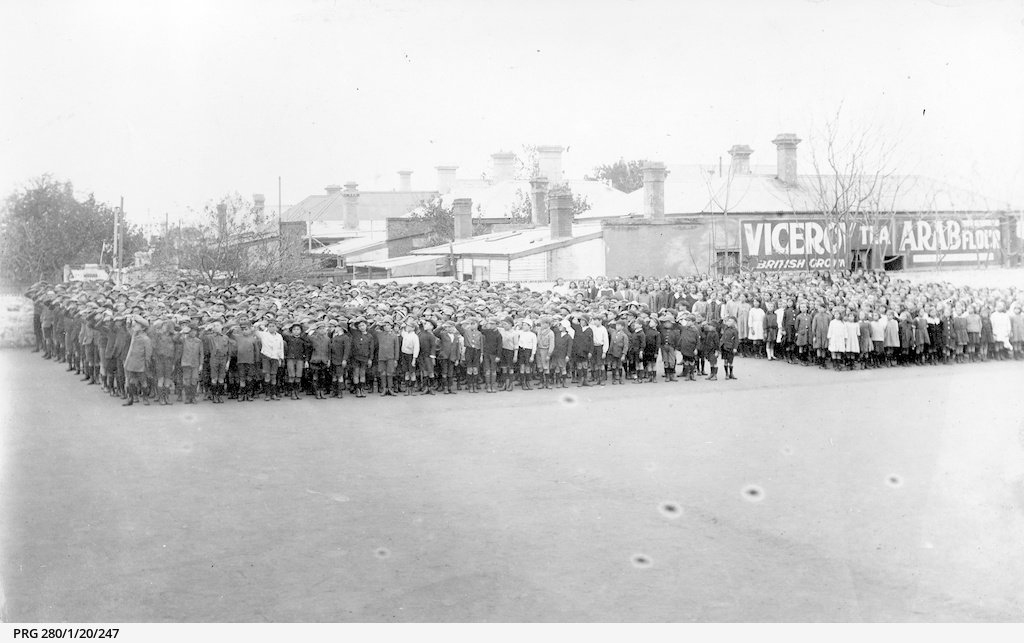 Assembly of children in their school yard saluting the flag ...
