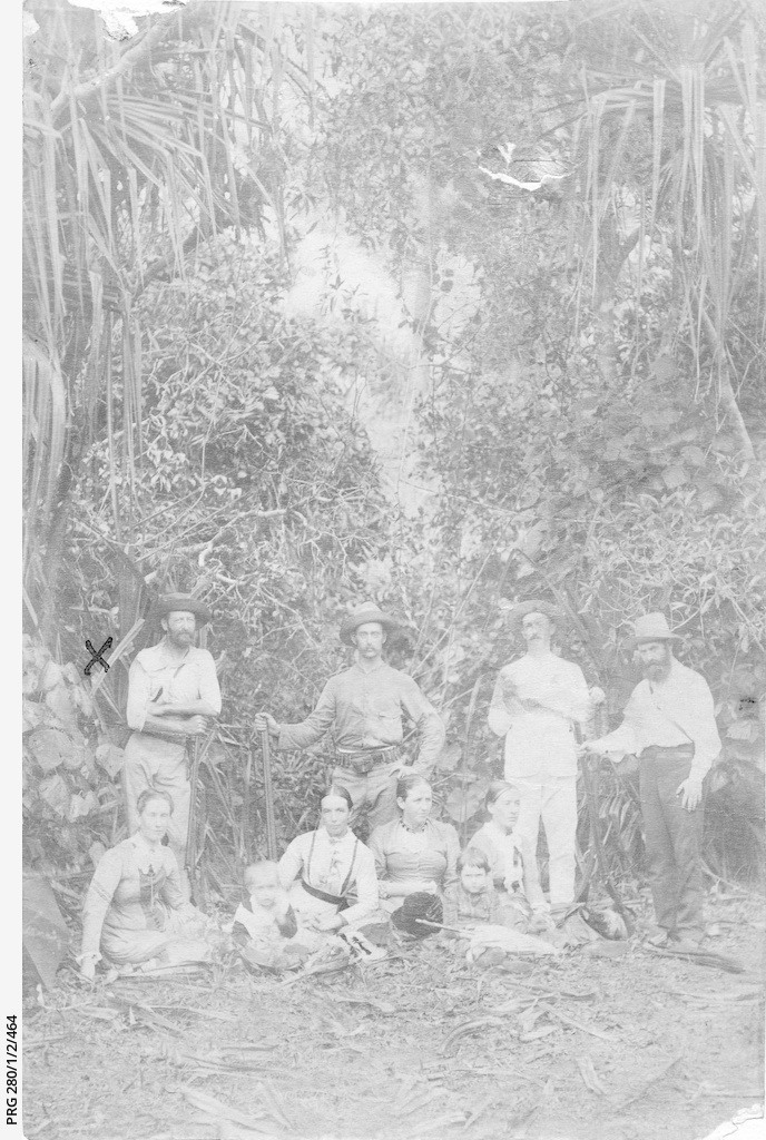 A group of men and women with two small children near jungle country ...