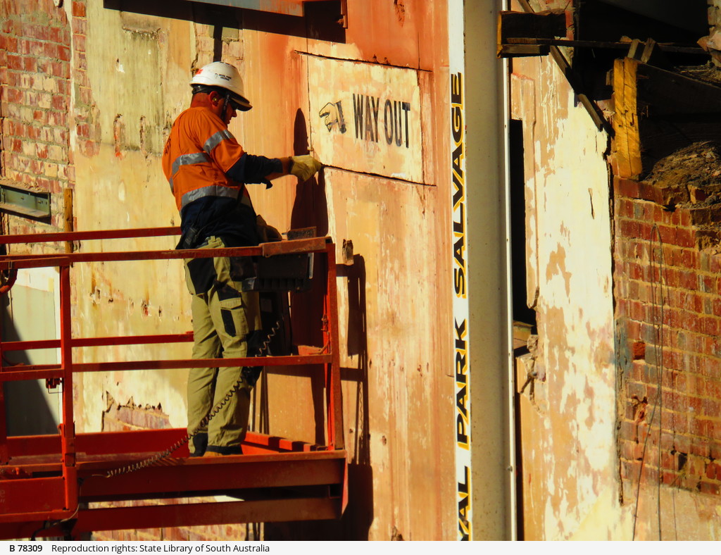 Worker cutting out a 'Way Out' sign at Her Majesty's Theatre ...