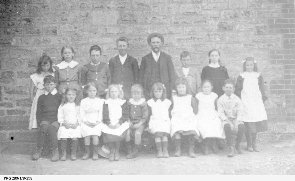 Pupils with their teacher, Miss Tucker, and an unidentified man outside ...
