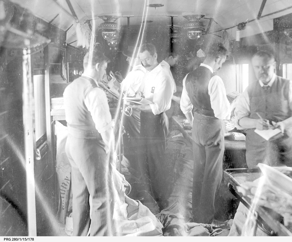 Men sorting letters and packages on a mail train in South Australia ...